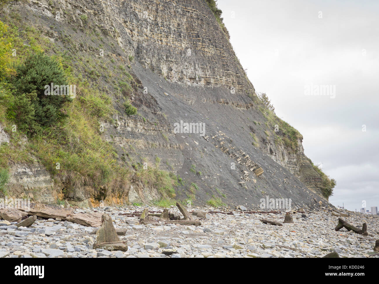 Fallen rock and broken reinforced concrete lumps on beach, and rock ...