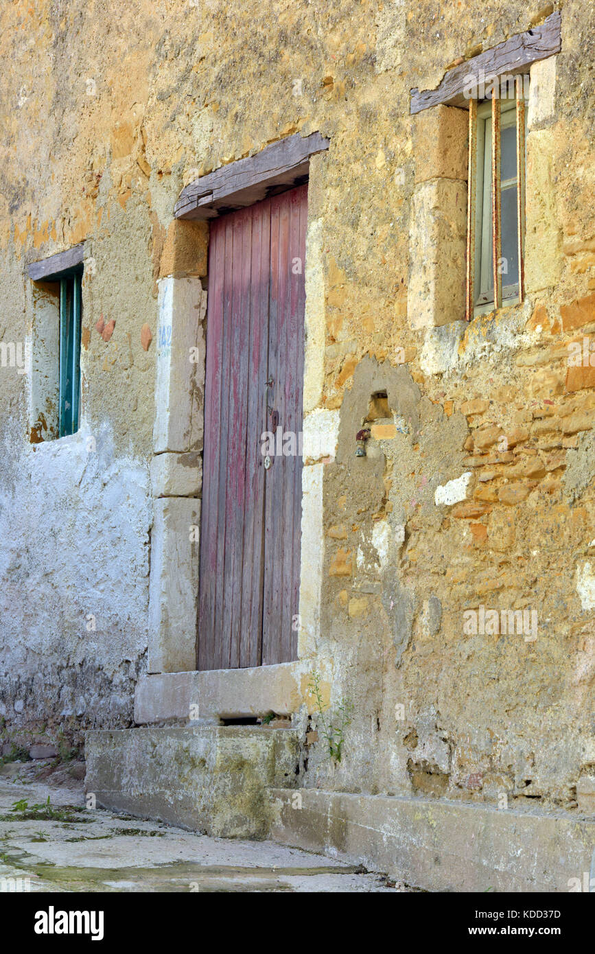 a door or entrance and two windows on an old country rustic or rural ...