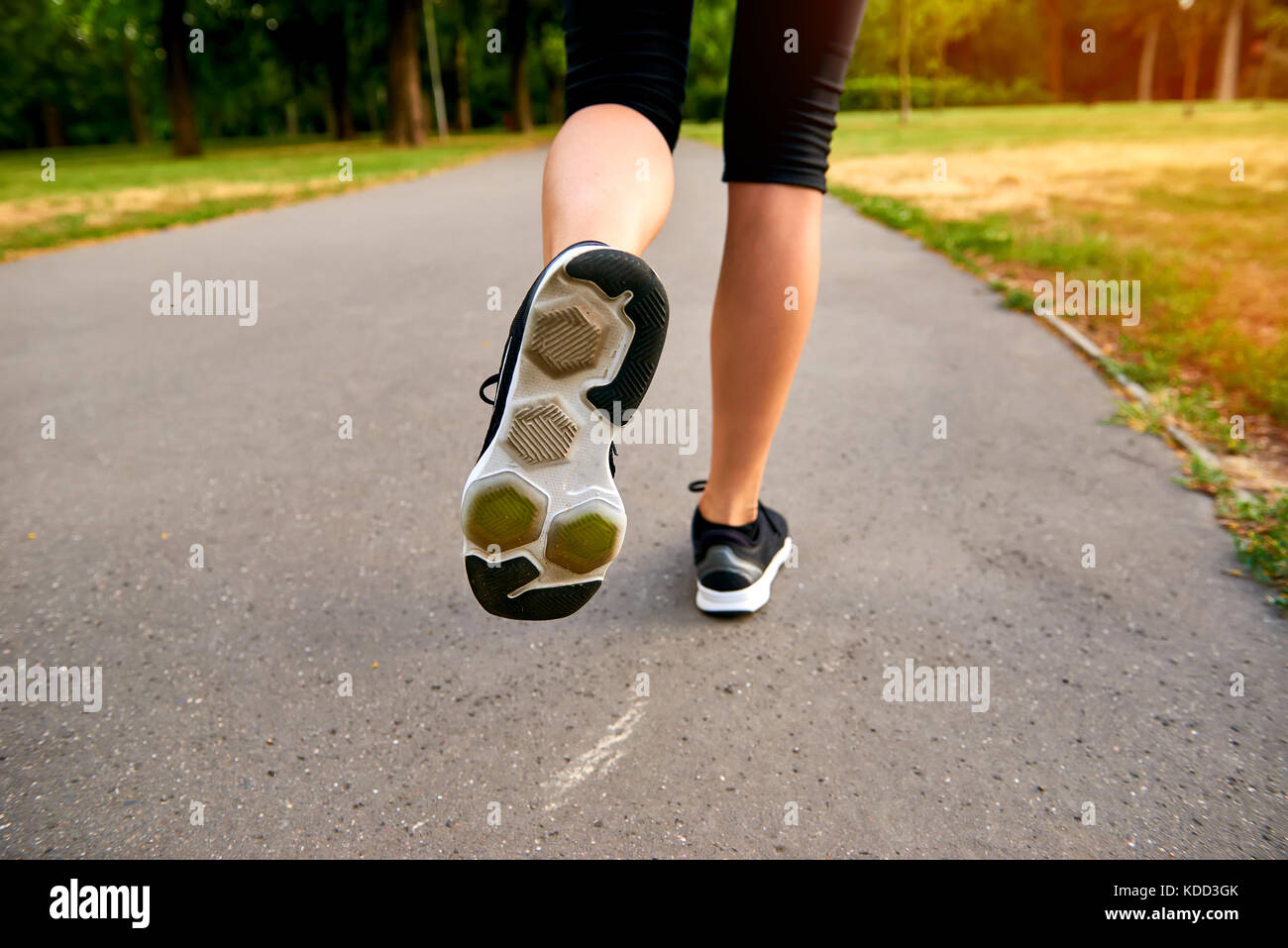 Close up from the back of a young blonde woman running away from the ...