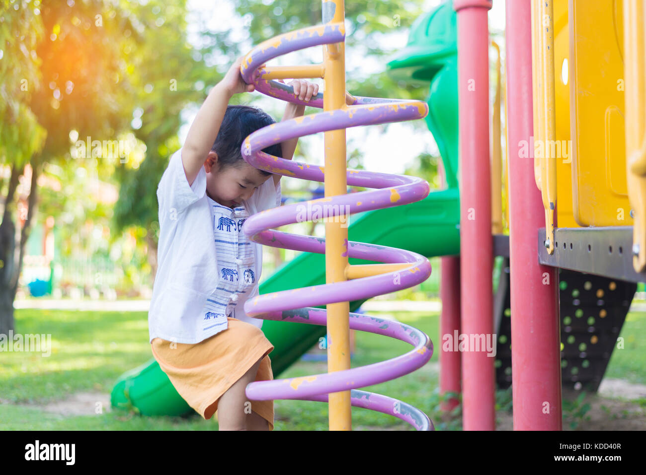 Active little child playing climbing spring metal at school yard ...