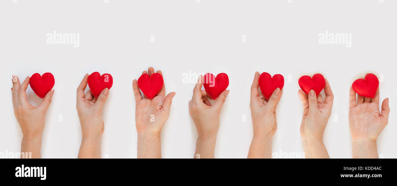 Many hands holding the heart. White background Stock Photo - Alamy