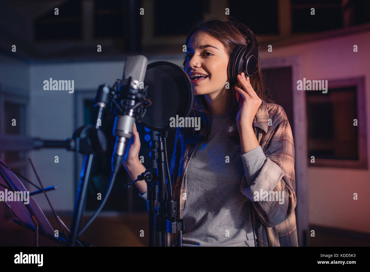 Young female singer recording album in the professional studio. Woman ...