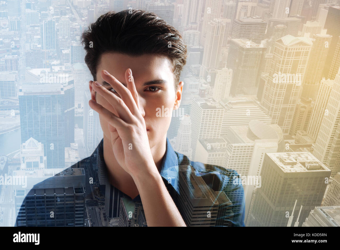 Calm teenager keeping left hand in front of his face Stock Photo - Alamy