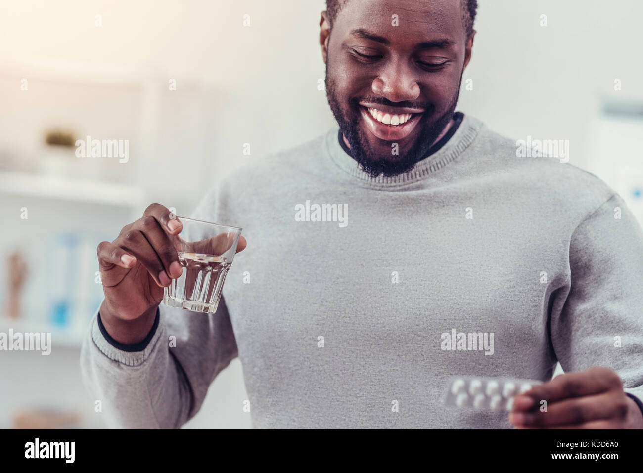 Positive minded African American man taking medication Stock Photo - Alamy