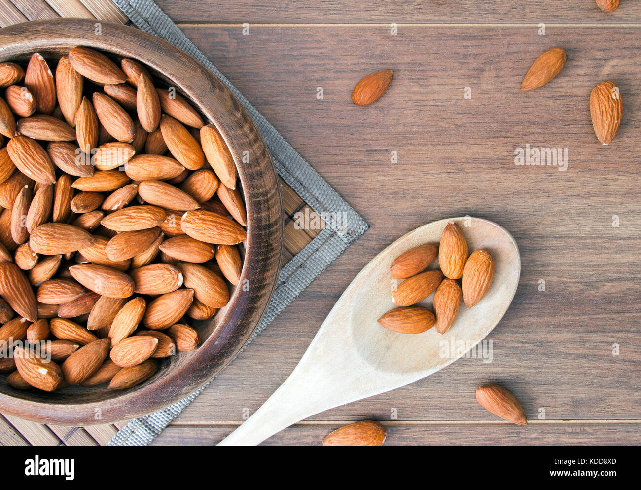 Almonds in a bowl on wooden background Stock Photo - Alamy
