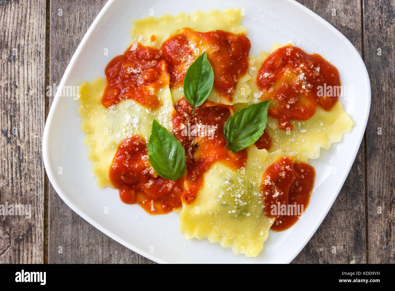 Ravioli with tomato sauce and basil on wooden table Stock Photo - Alamy
