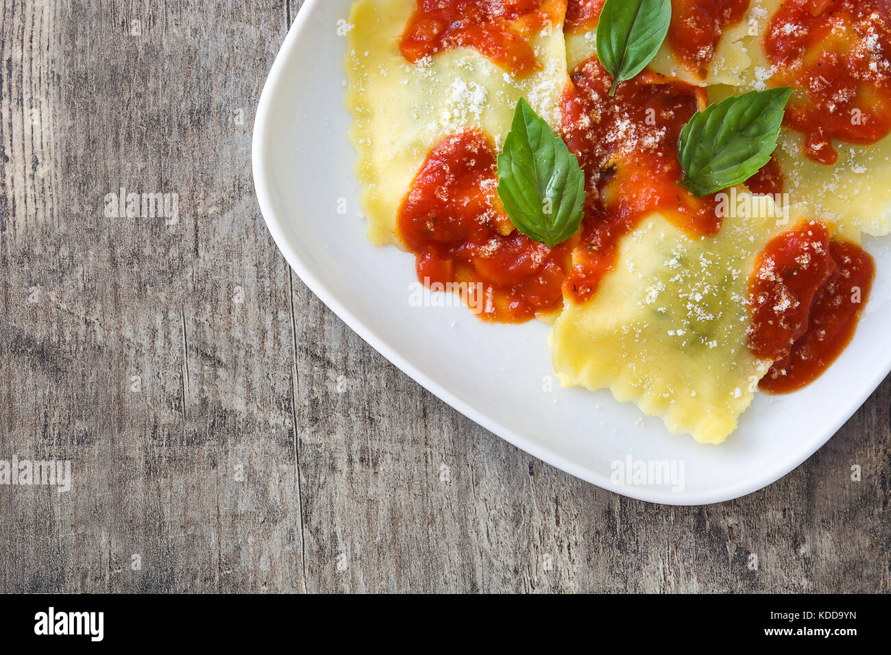 Ravioli with tomato sauce and basil on wooden table Stock Photo - Alamy
