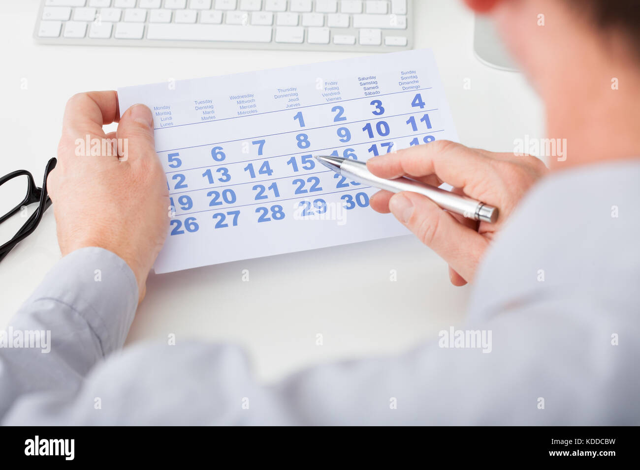 Close-up Of Man Marking With Pen And Looking At Date On Calendar Stock ...