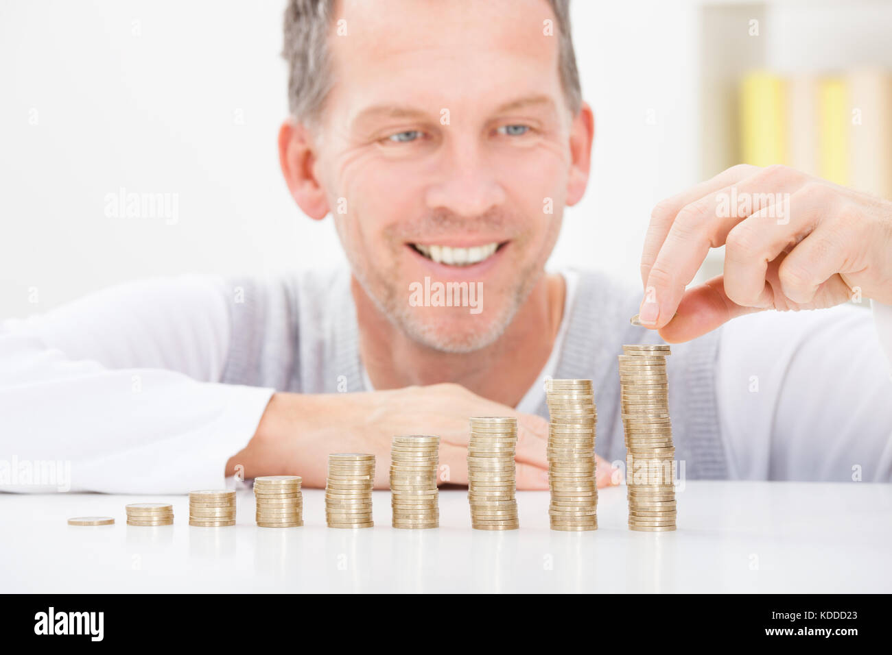 Portrait Of Happy Mature Man Sitting At Home Stacking Coins Stock Photo ...