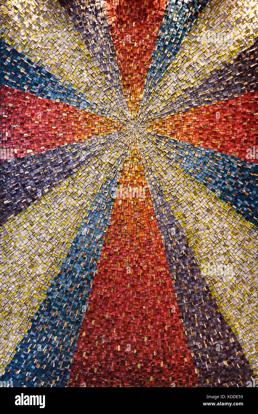 Sunburst cross in colorful mosaic tile backdrop in Roman Catholic ...