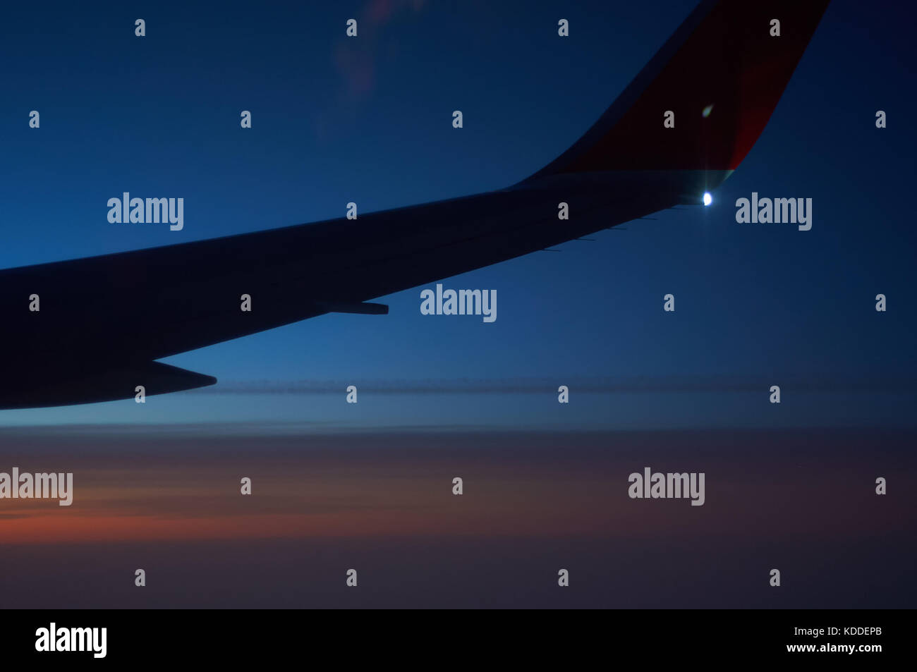 Airplane wing in colorful early morning sky Stock Photo - Alamy