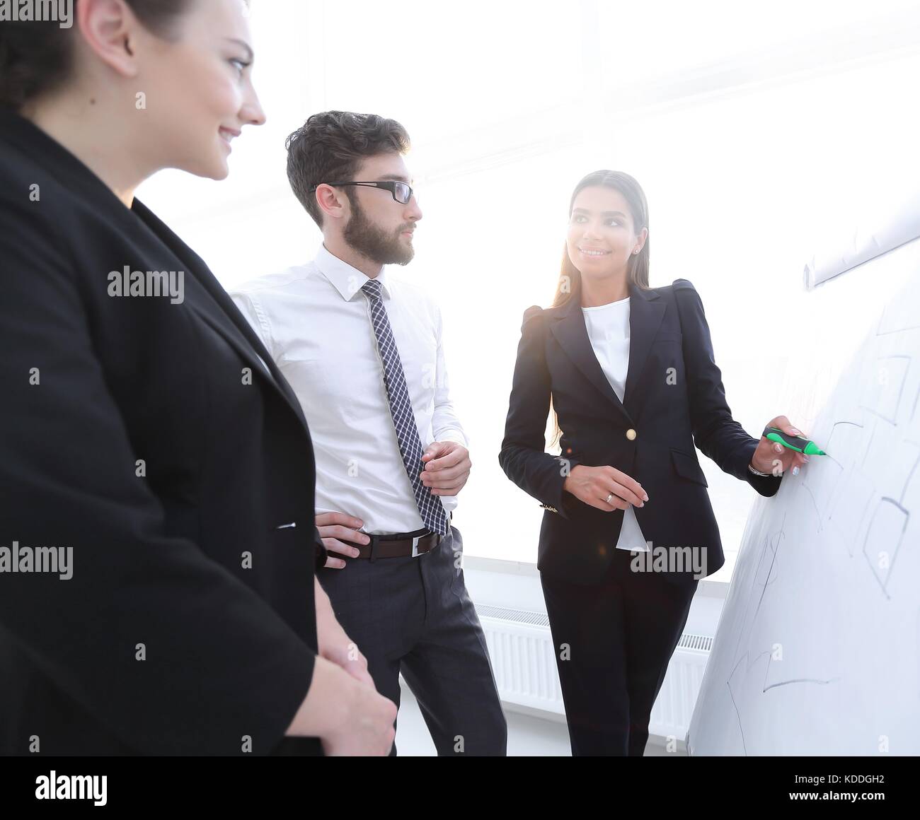 businesswoman pointing marker to flipboard on presentation in office ...