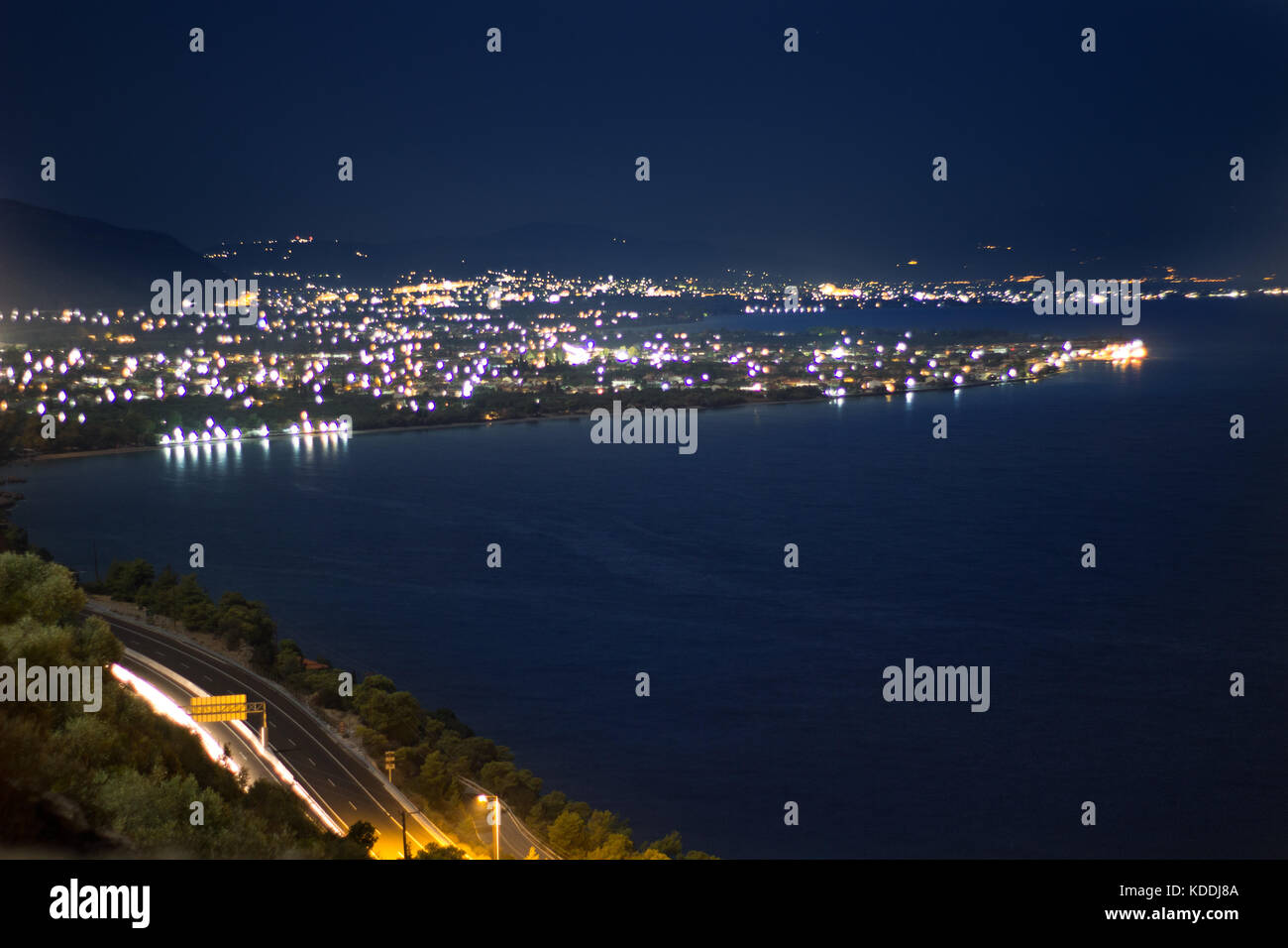 nightscape scenery of a highway ocean and a town on the horizon Stock ...