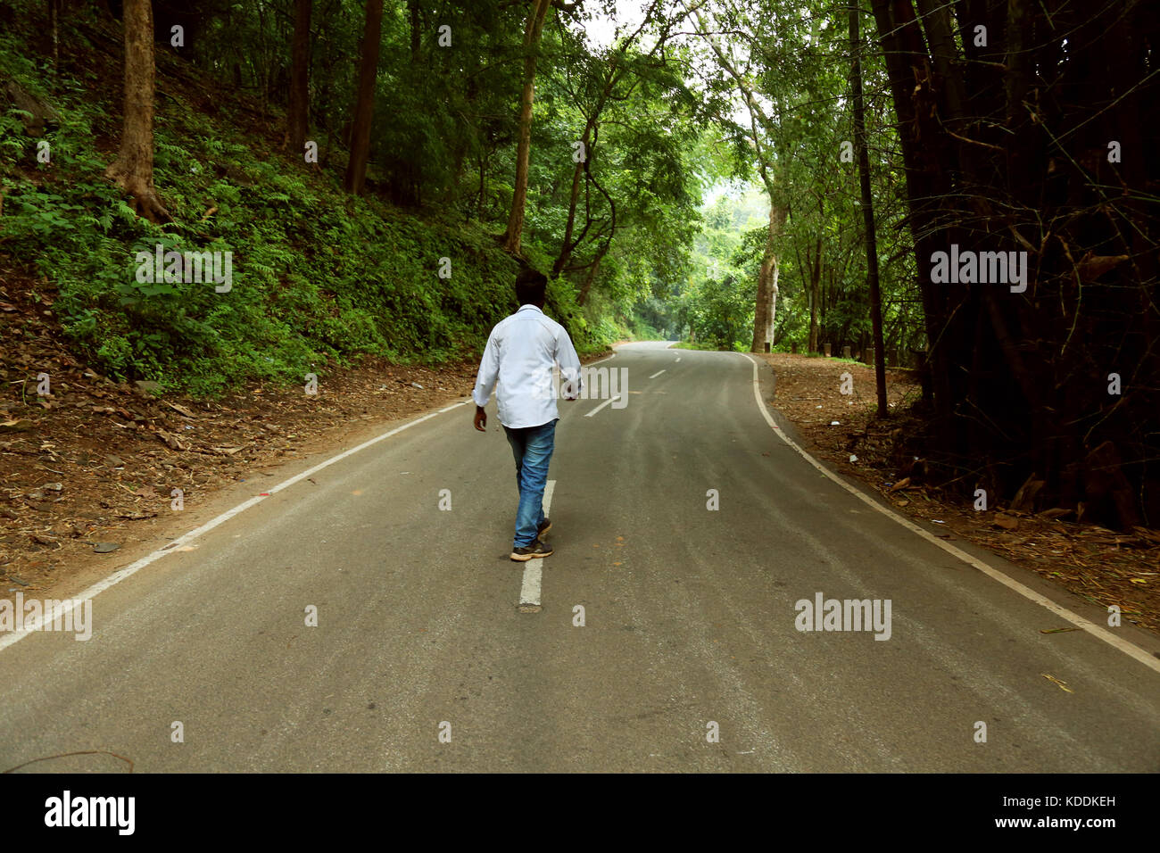 Man walking along the road Stock Photo - Alamy