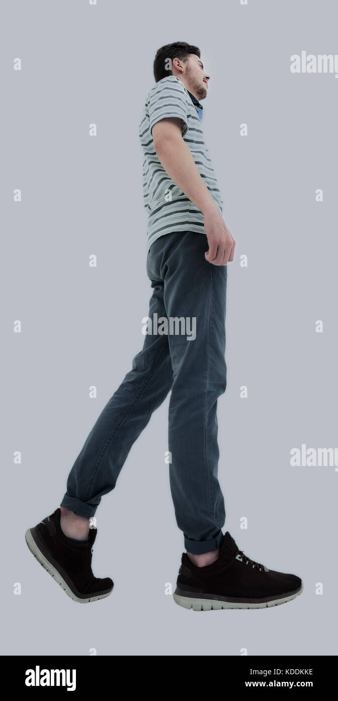 Side view of a smiling young casual man walking , On white backg Stock ...