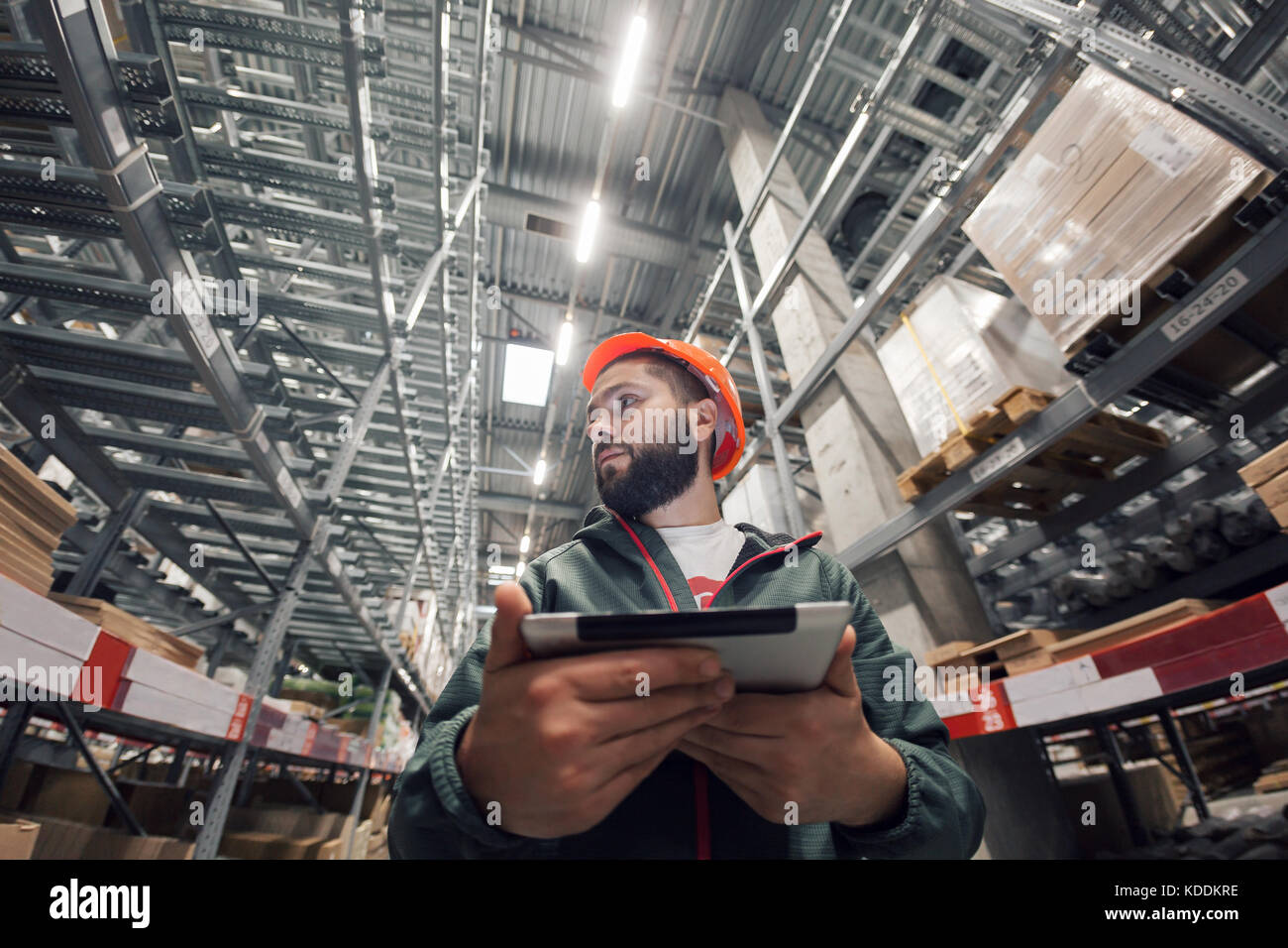 Warehouse manager checking his inventory in a large warehouse Stock ...