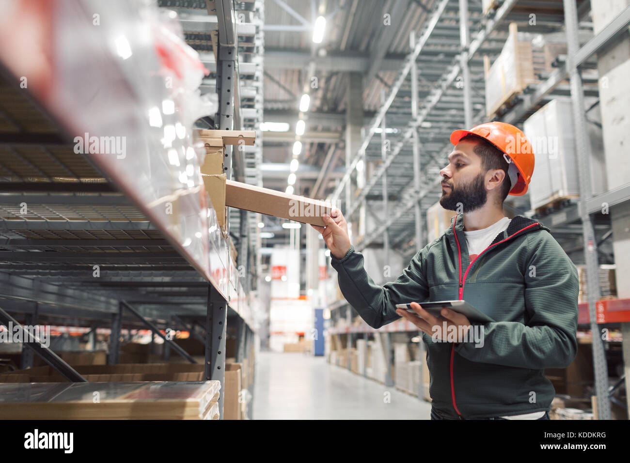 Warehouse manager checking his inventory in a large warehouse Stock ...