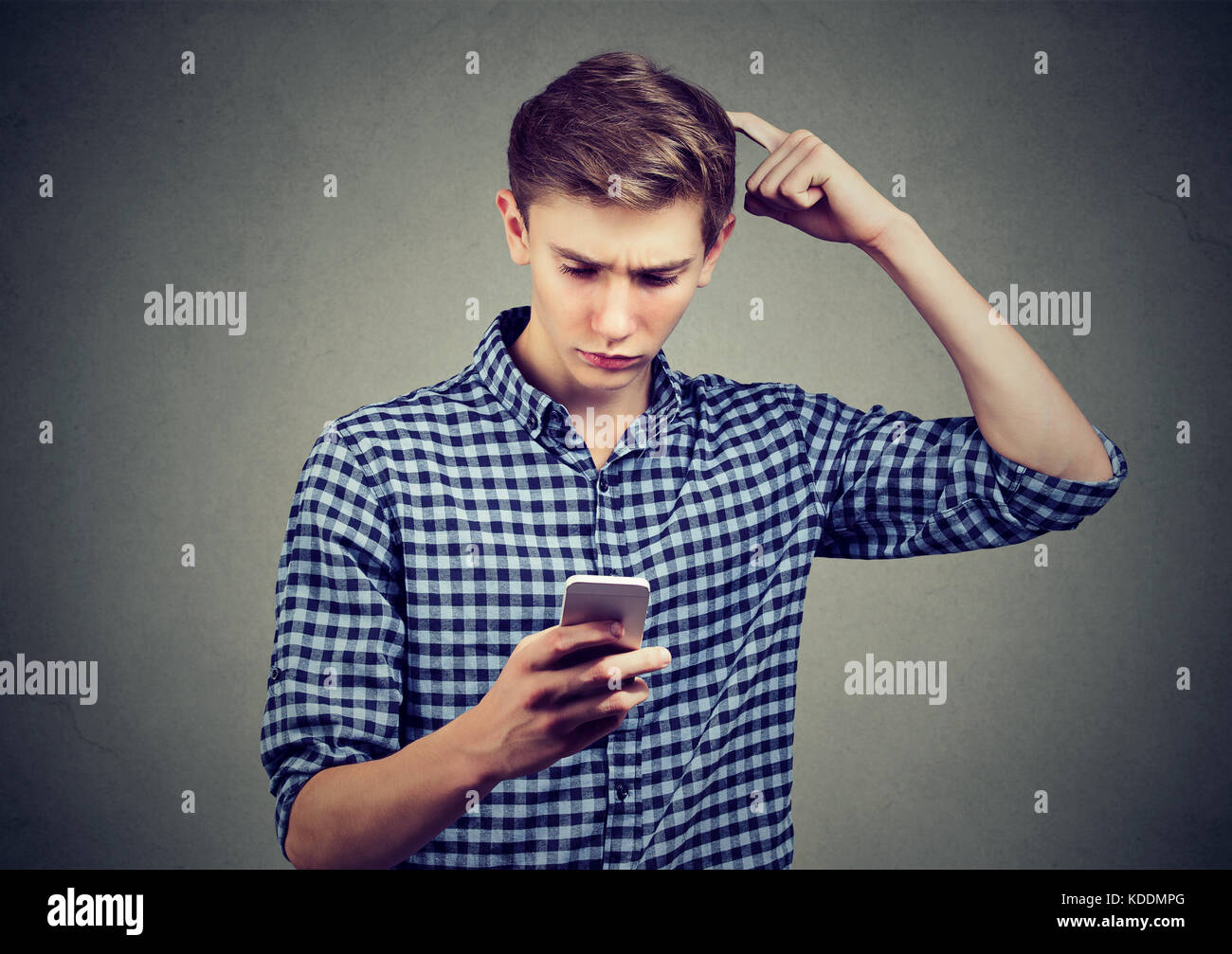 Closeup portrait young man dumbfounded about what he sees on cellphone ...