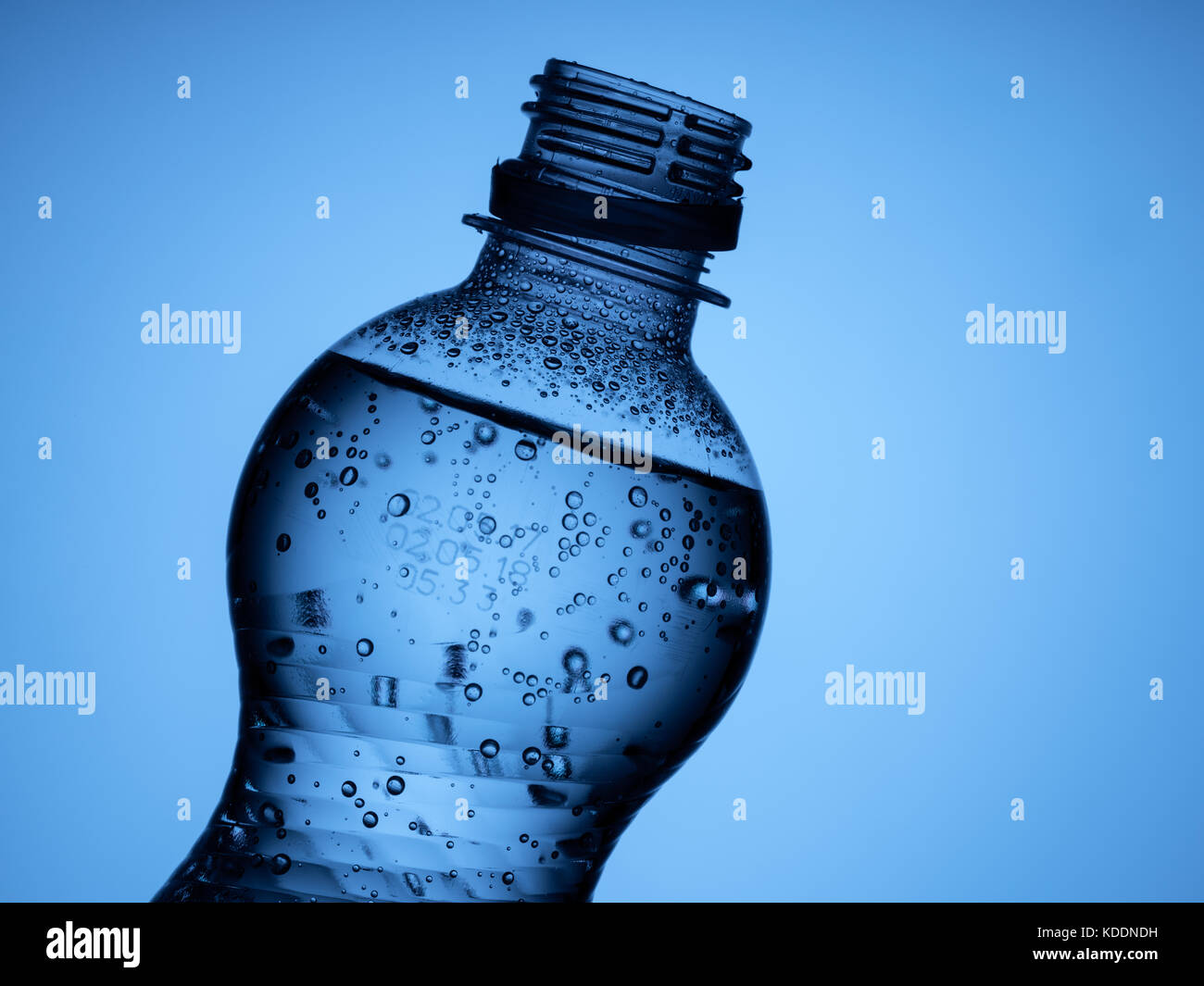 one open bottle of sparkling water is isolated on a blue background ...