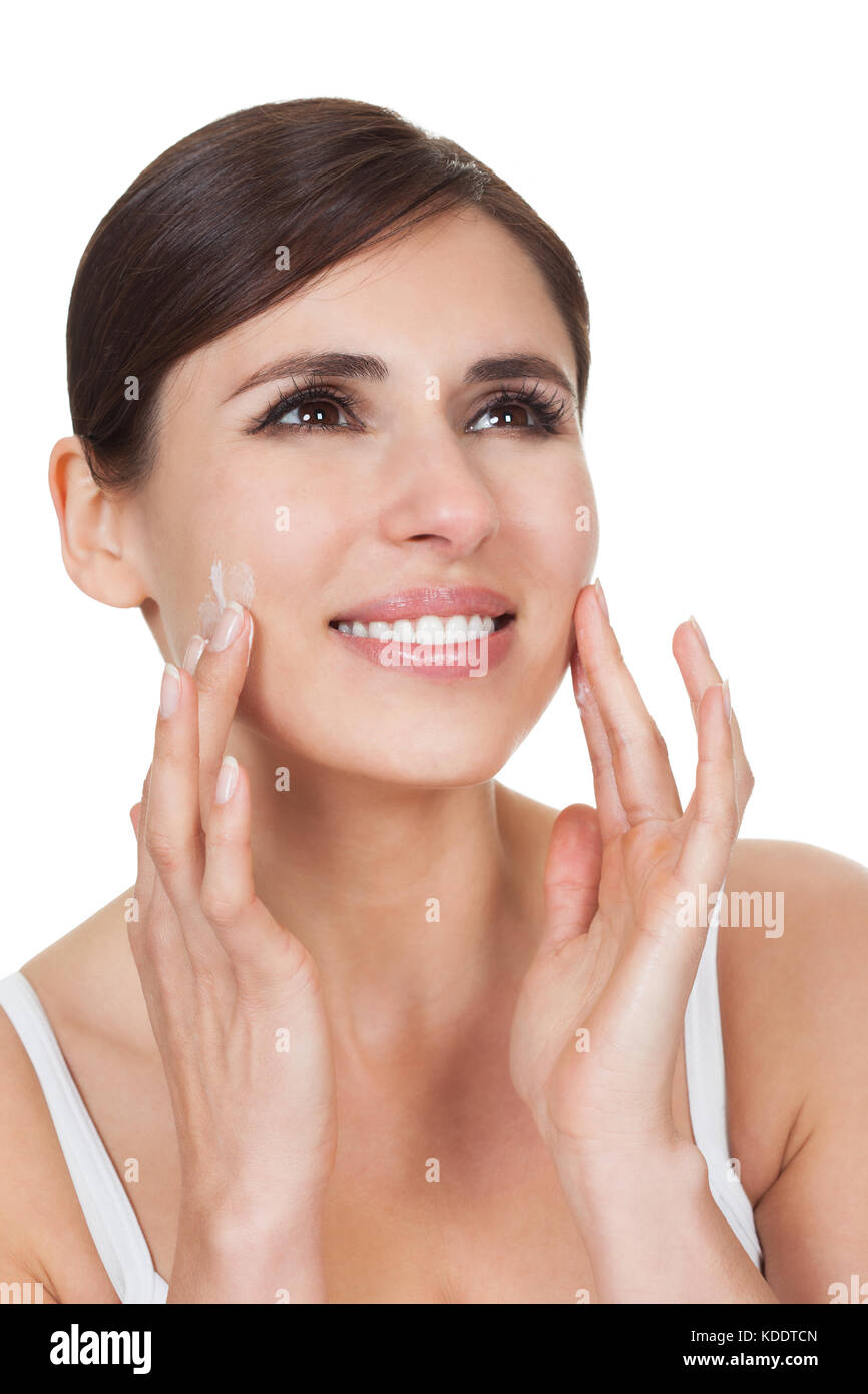 Pretty Young Woman Putting Cream On Her Skin Stock Photo - Alamy