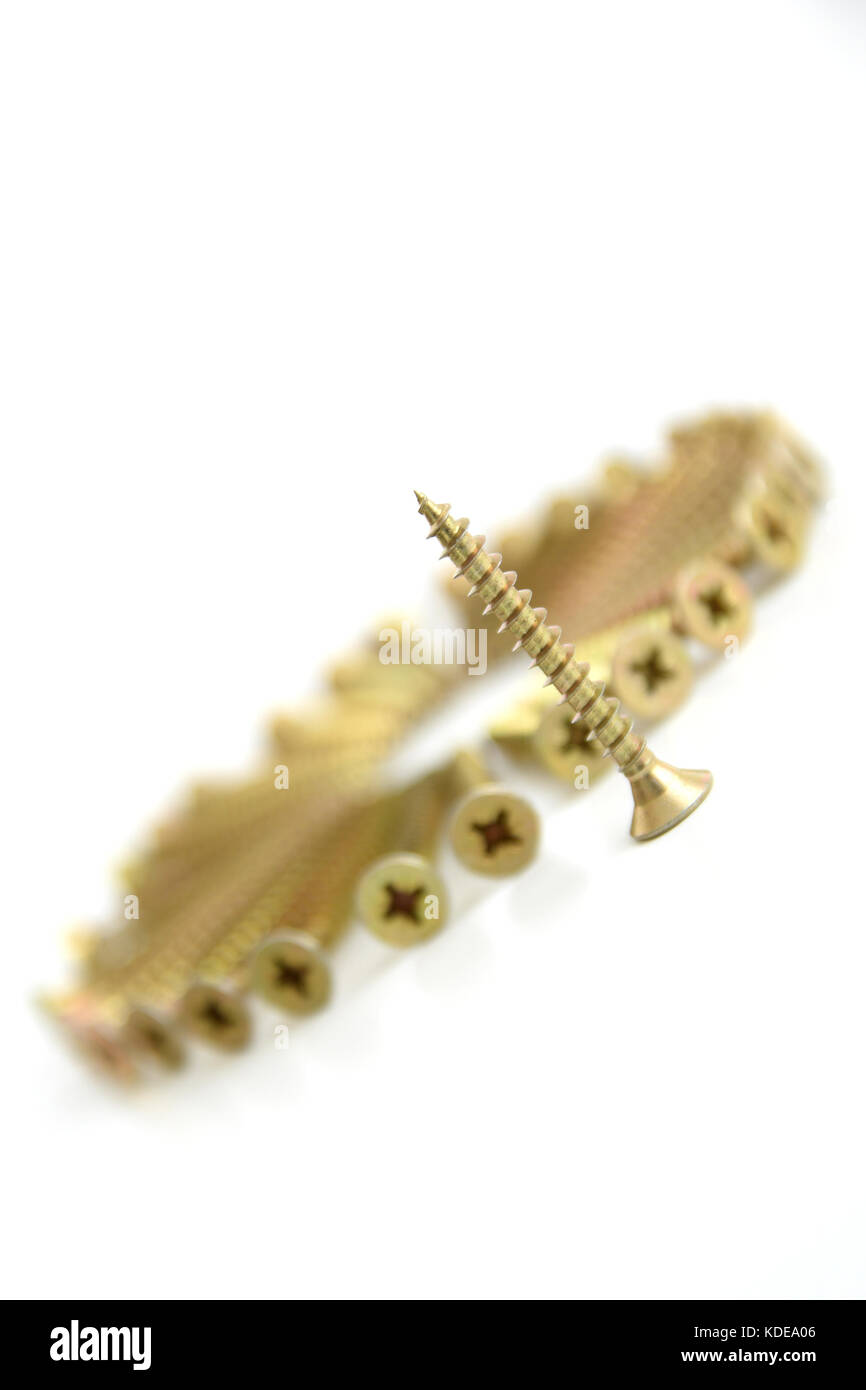 Circle of brass screws on white background with one odd man out Stock ...