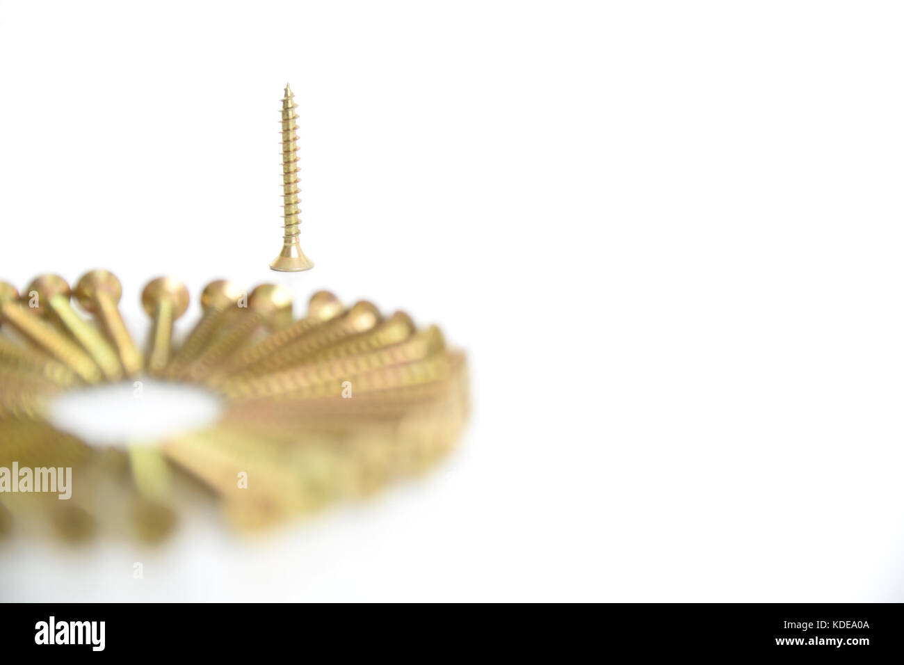 Circle of brass screws on white background with one odd man out Stock ...
