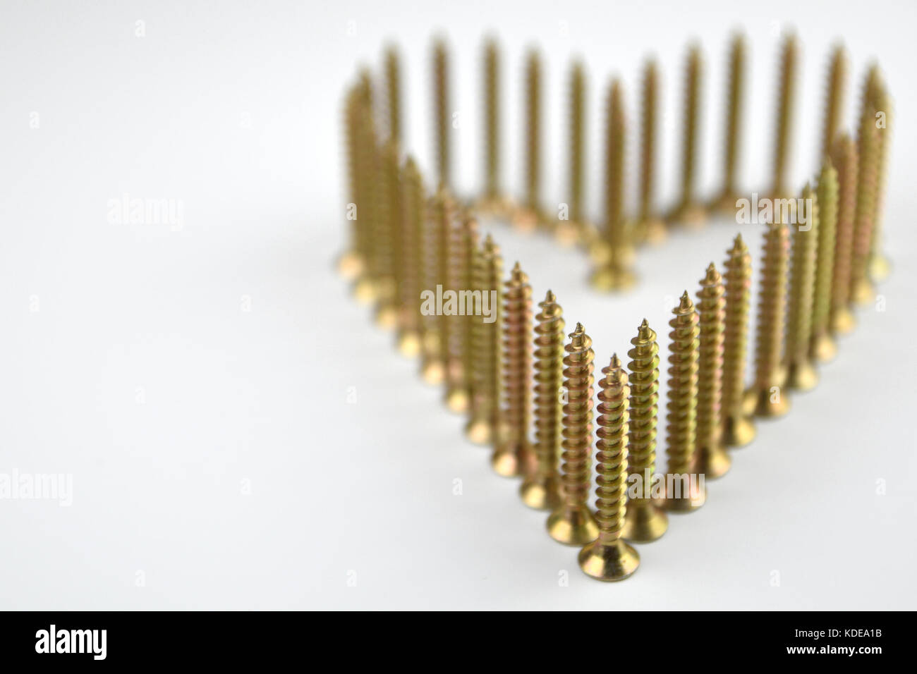 Love heart made from standing brass screws on white background Stock ...