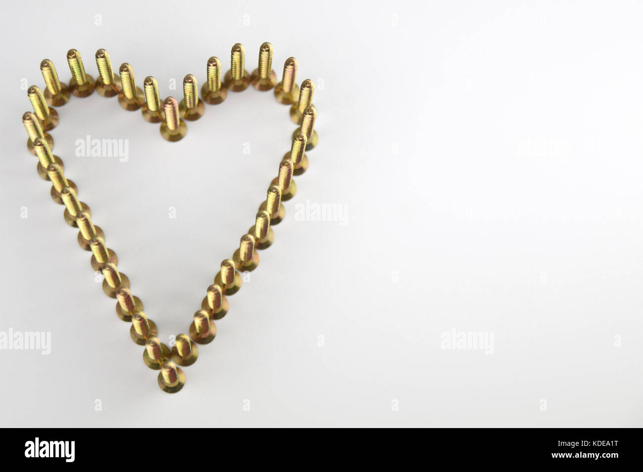 Love heart made from standing brass screws on white background Stock ...