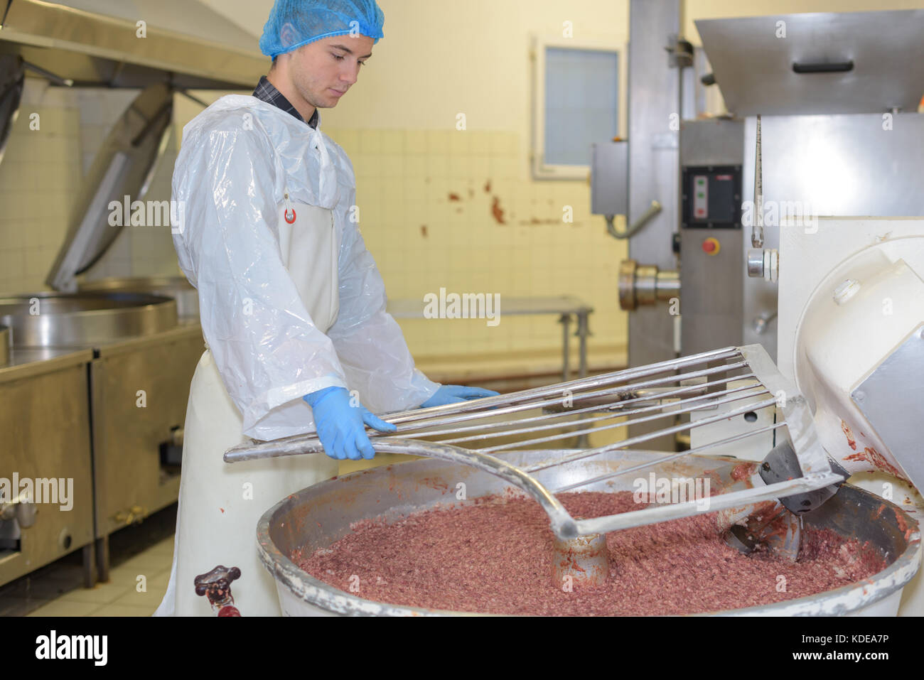 Factory worker stood by mixing vat Stock Photo - Alamy