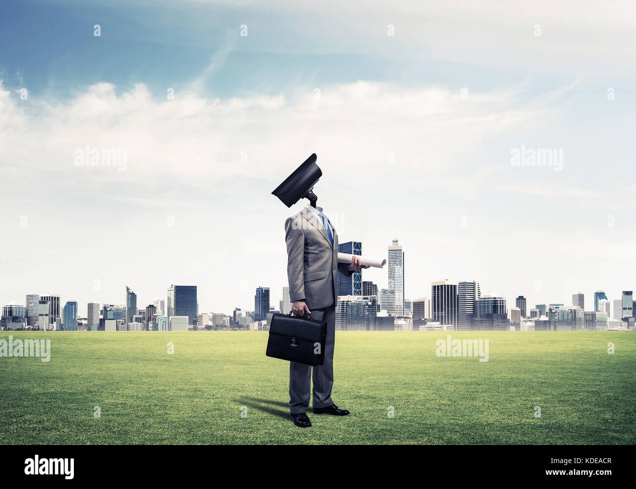 Camera headed man standing on green grass against modern citysca Stock ...