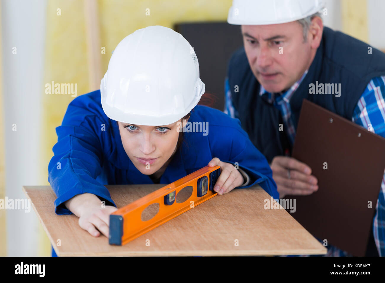 female apprentice construction worker with level Stock Photo - Alamy