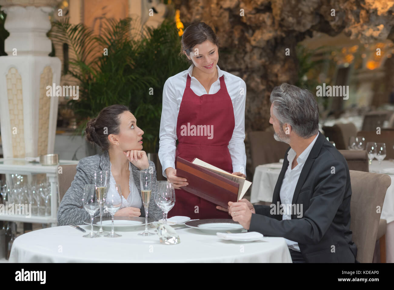waitress serving a couple in a restaurant Stock Photo - Alamy