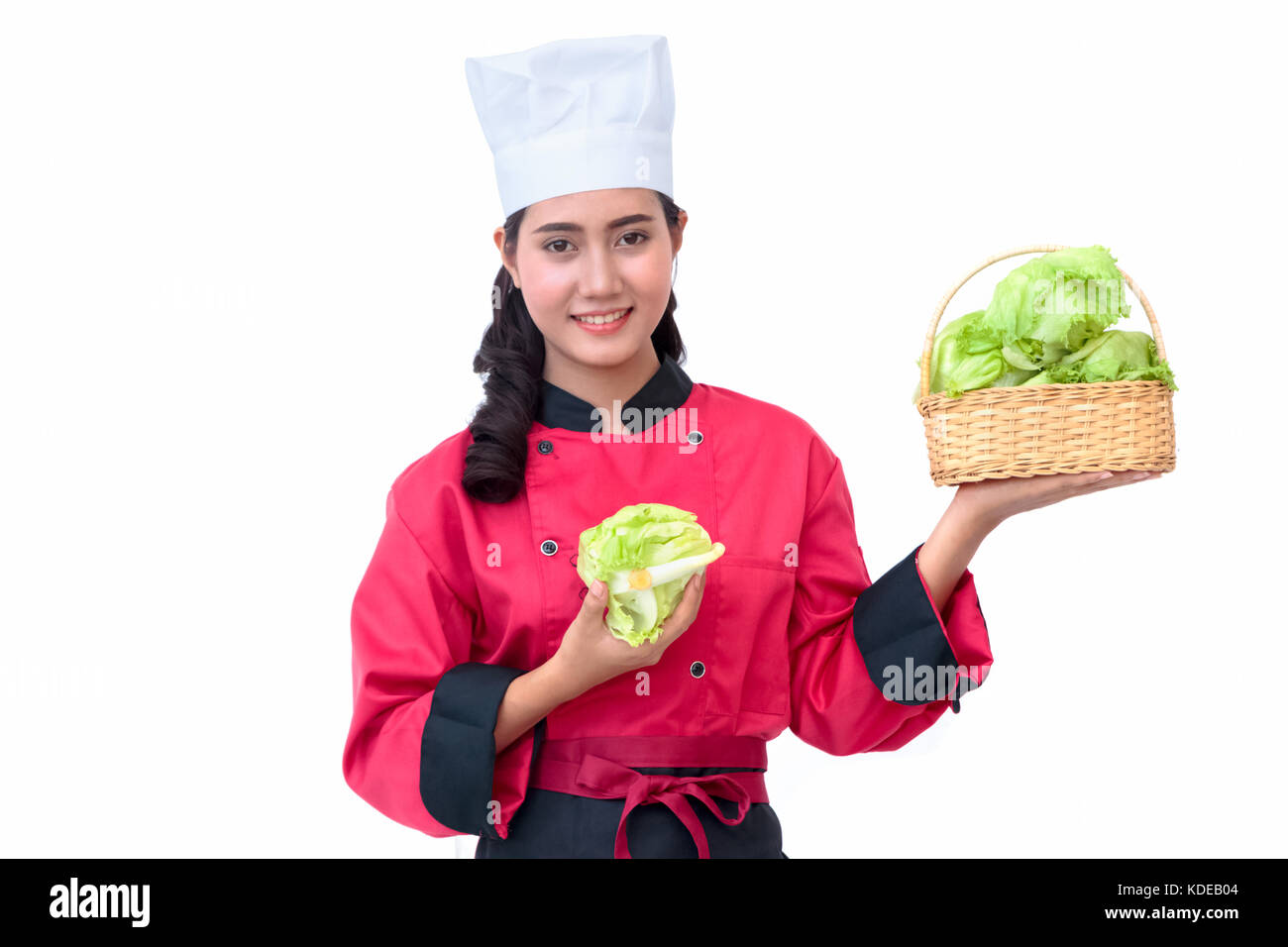 Smiling chef woman in red uniform holding vegetable basket Stock Photo ...