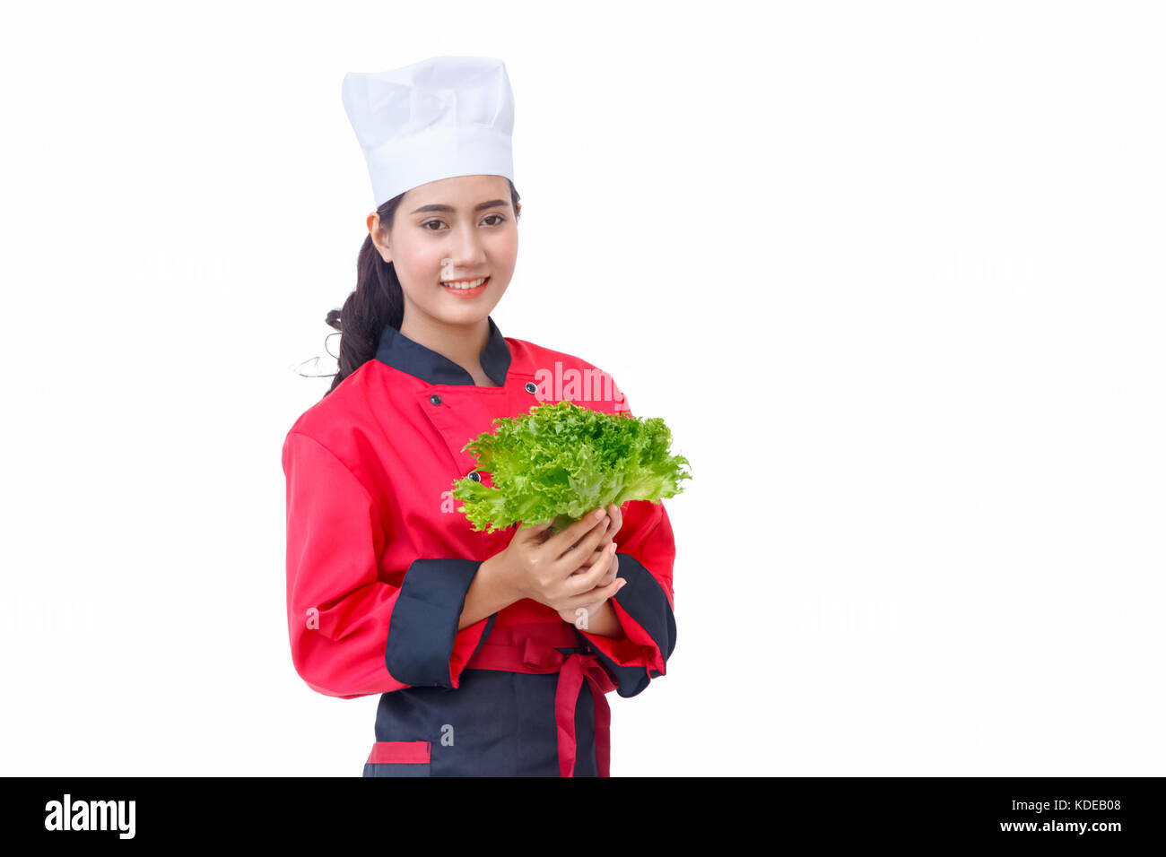 Smiling chef woman in red uniform holding vegetable Stock Photo - Alamy