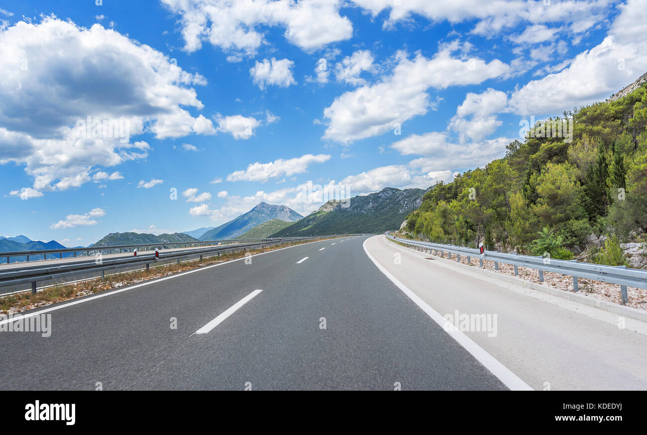 High-speed country road among the mountains on a summer day Stock Photo ...