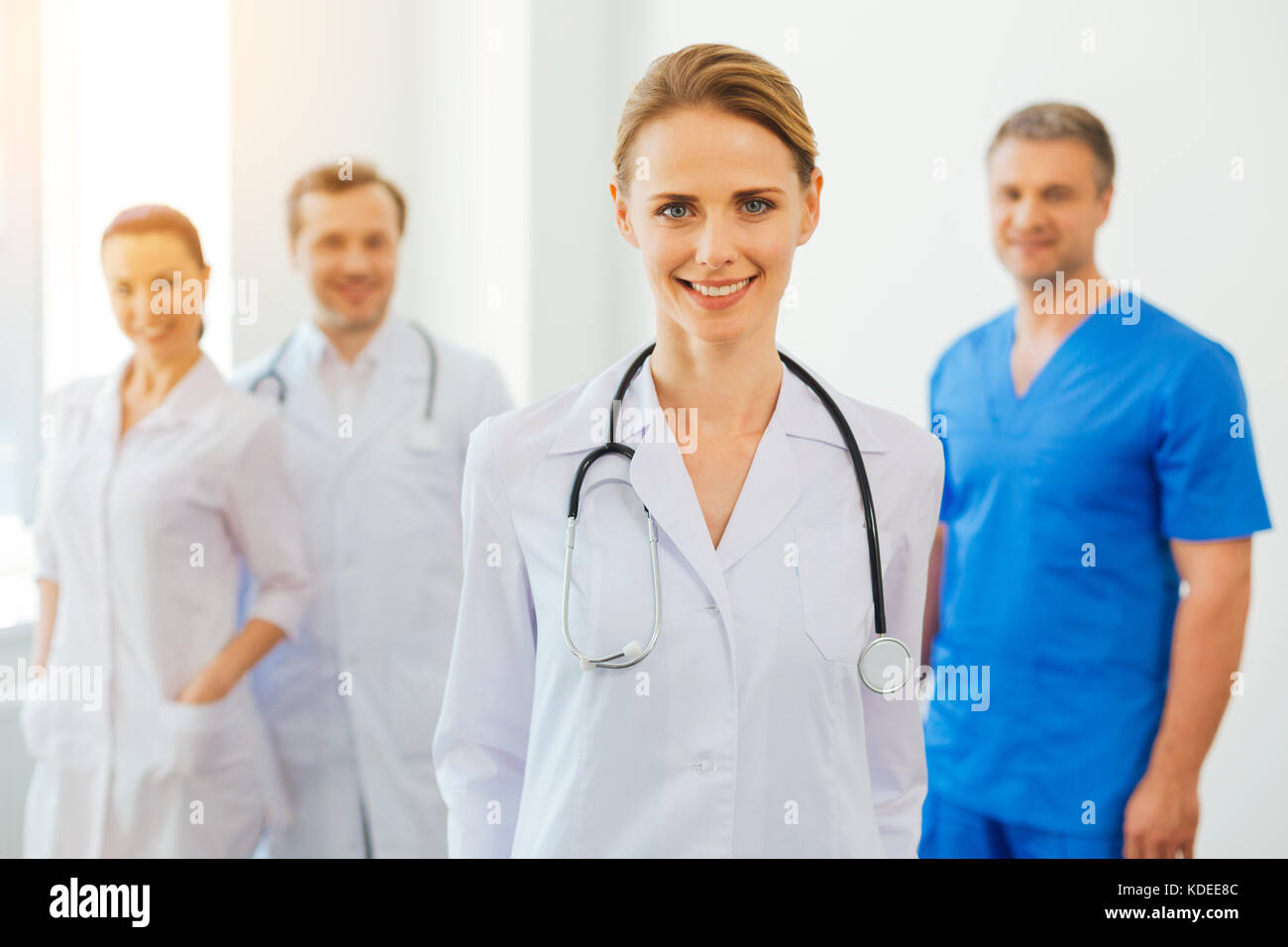 Positive minded female practitioner with stethoscope posing for camera ...