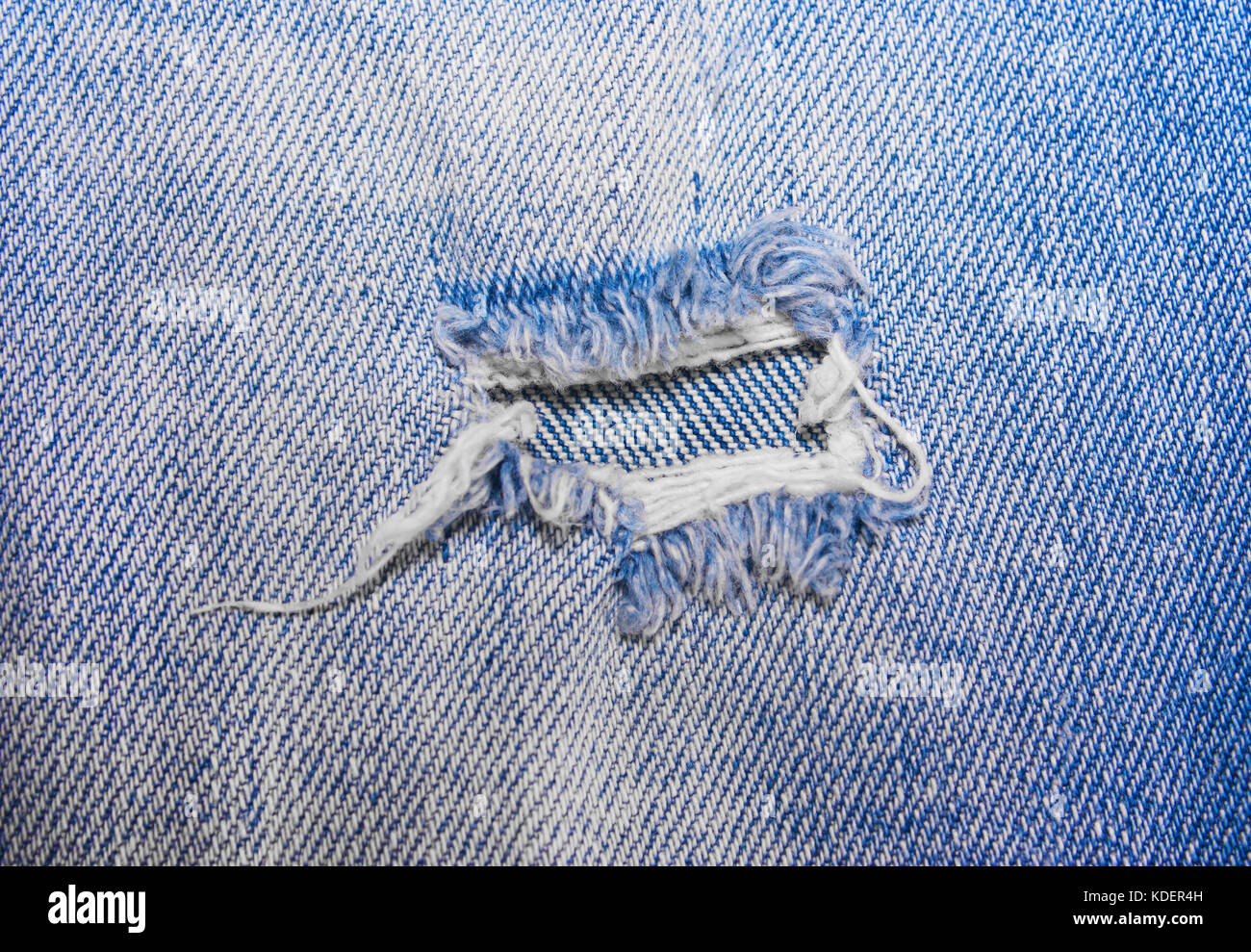 The hole on the blue jeans, denim texture Stock Photo - Alamy