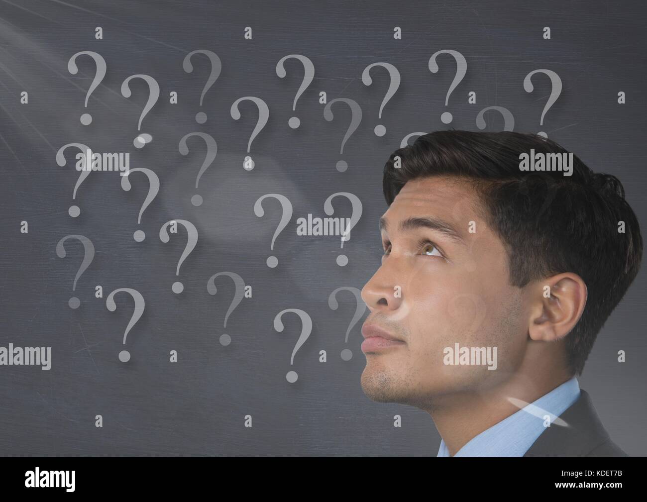 Digital composite of man looking up at question marks Stock Photo - Alamy