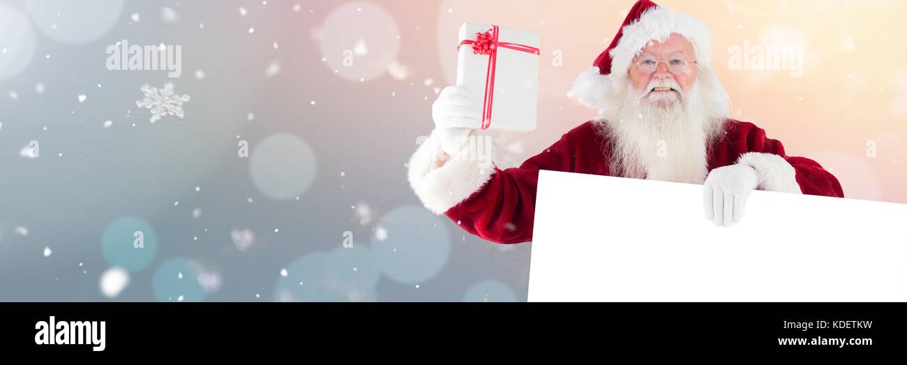 Digital composite of Santa with white card and gift Stock Photo - Alamy