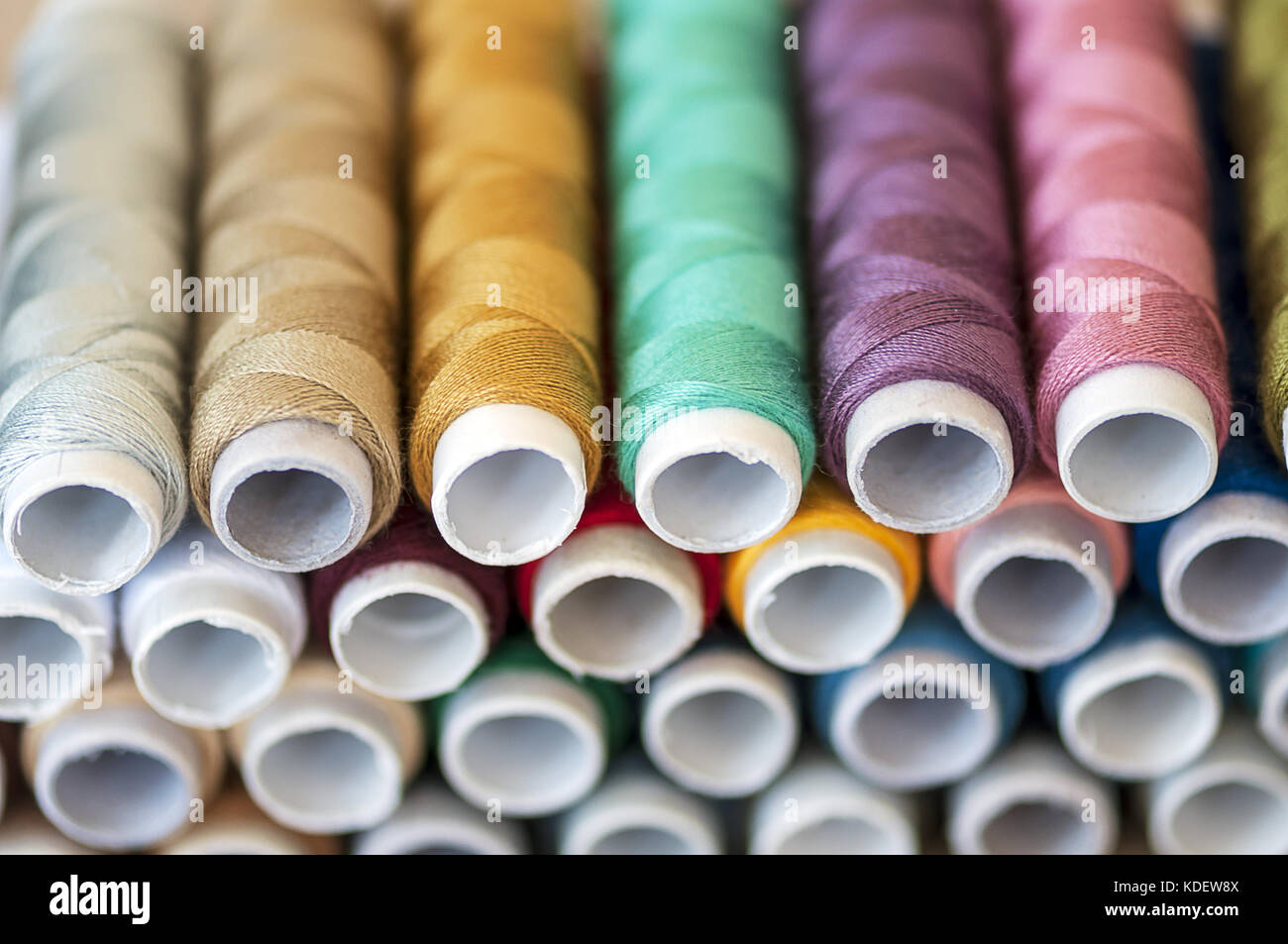 Close-up on colored sewing threads on spools Stock Photo - Alamy