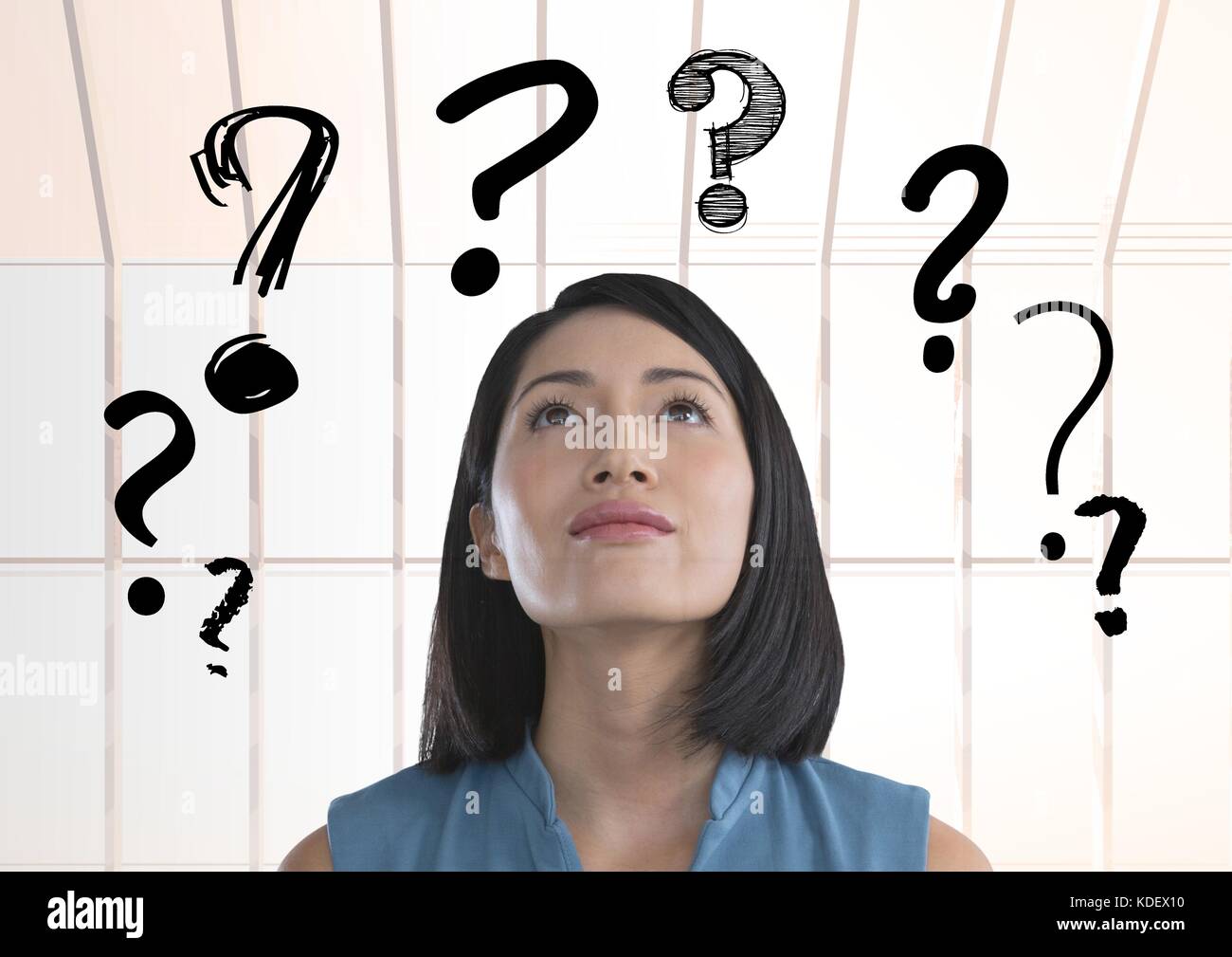 Digital composite of woman looking up at question mark Stock Photo - Alamy