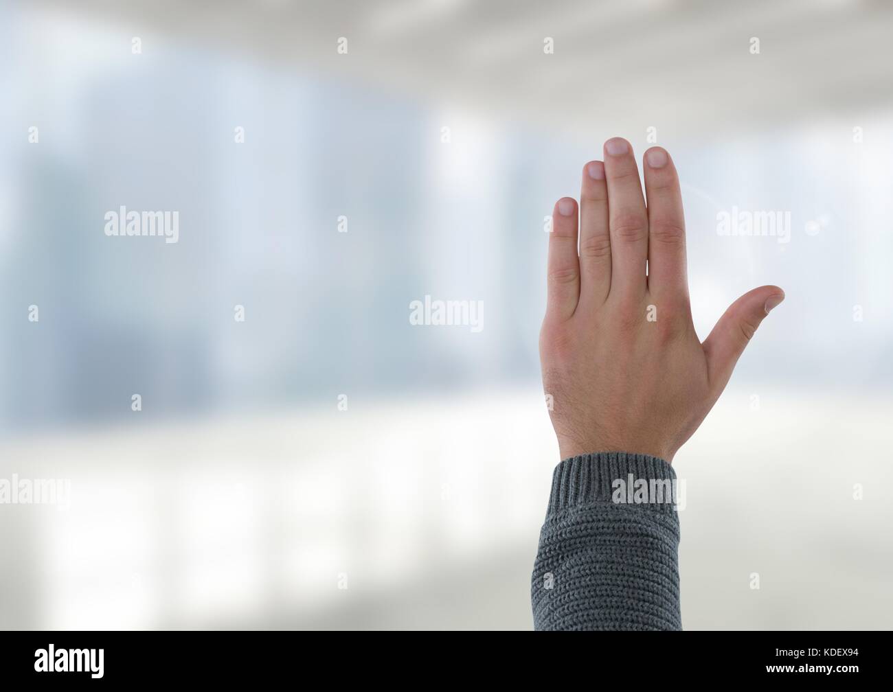 Digital composite of Hand open waving with bright windows in office ...