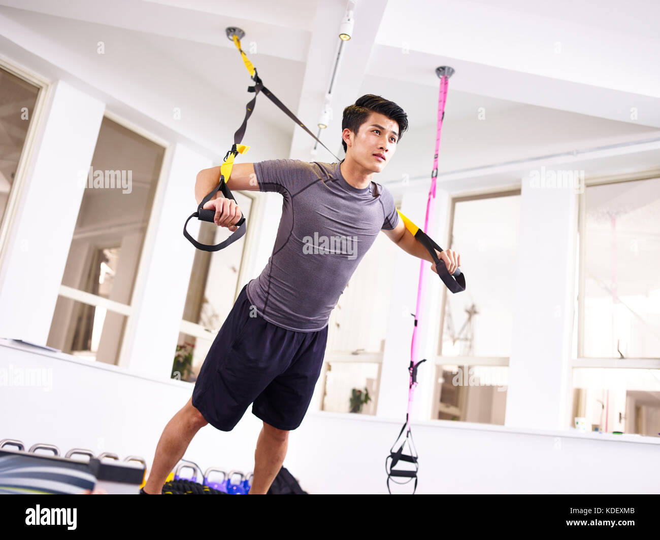 young asian man exercising in gym using fitness straps Stock Photo - Alamy