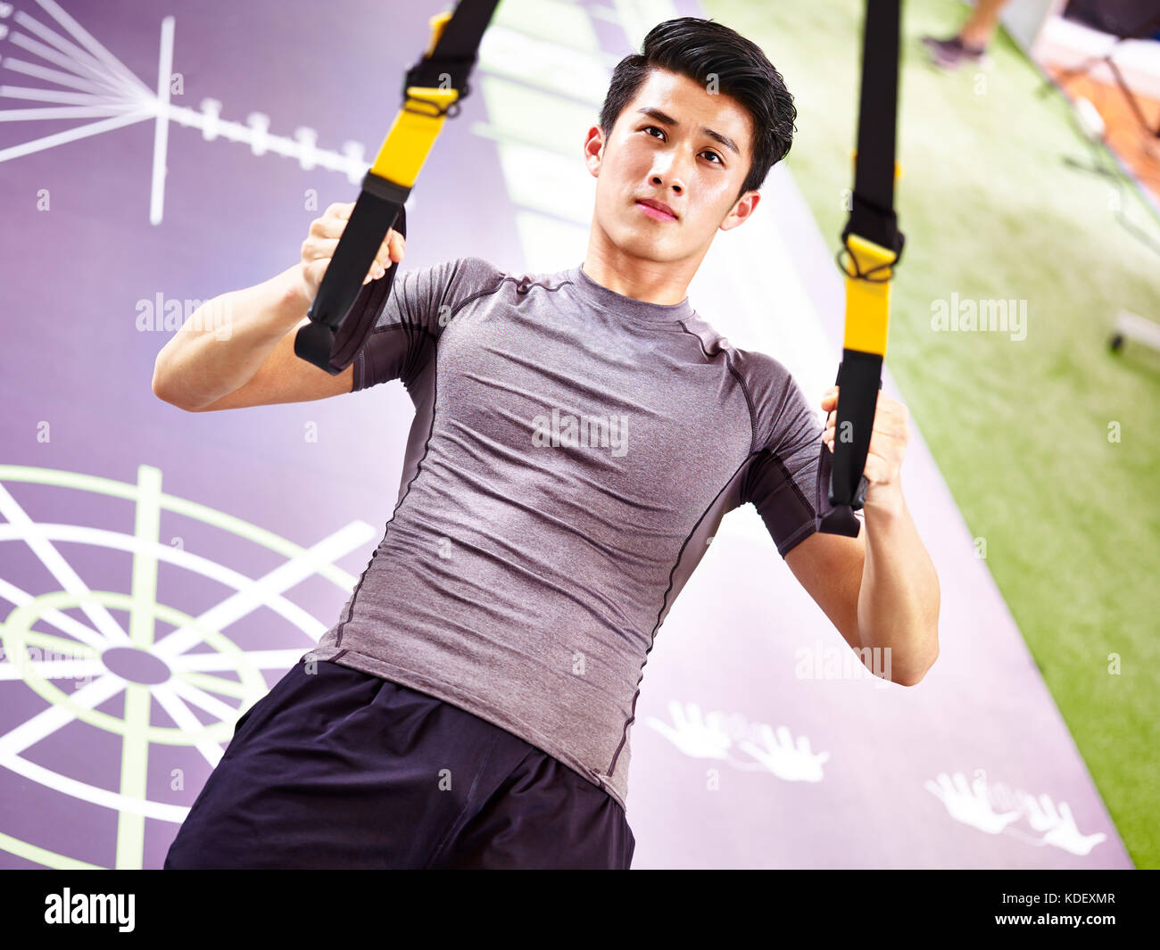 young asian man exercising in gym using fitness straps Stock Photo - Alamy