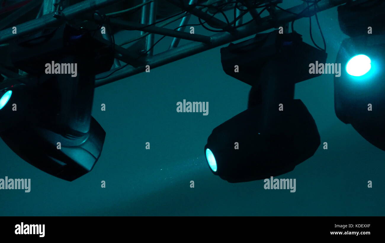 strobe lights emitting different color beams hanging under the ceiling ...