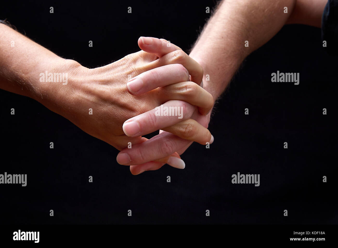 Male and female hands together on black background Stock Photo - Alamy