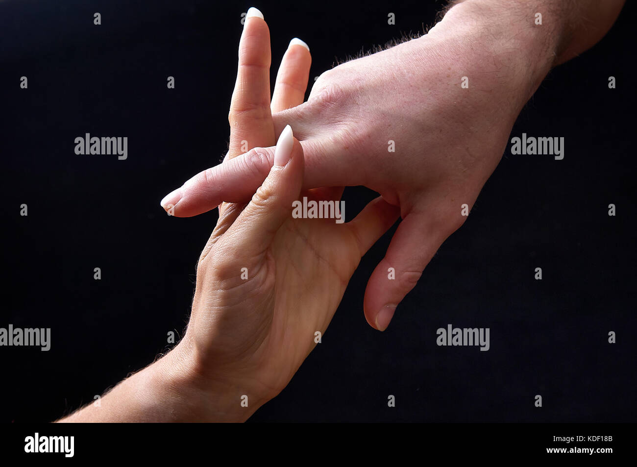 Male and female hands together on black background Stock Photo - Alamy
