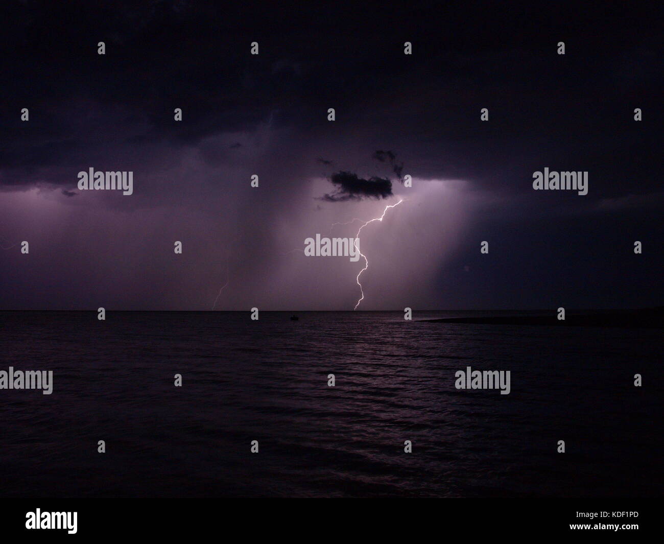 Thunderstorm with lightnings at the ocean shore at night Stock Photo ...