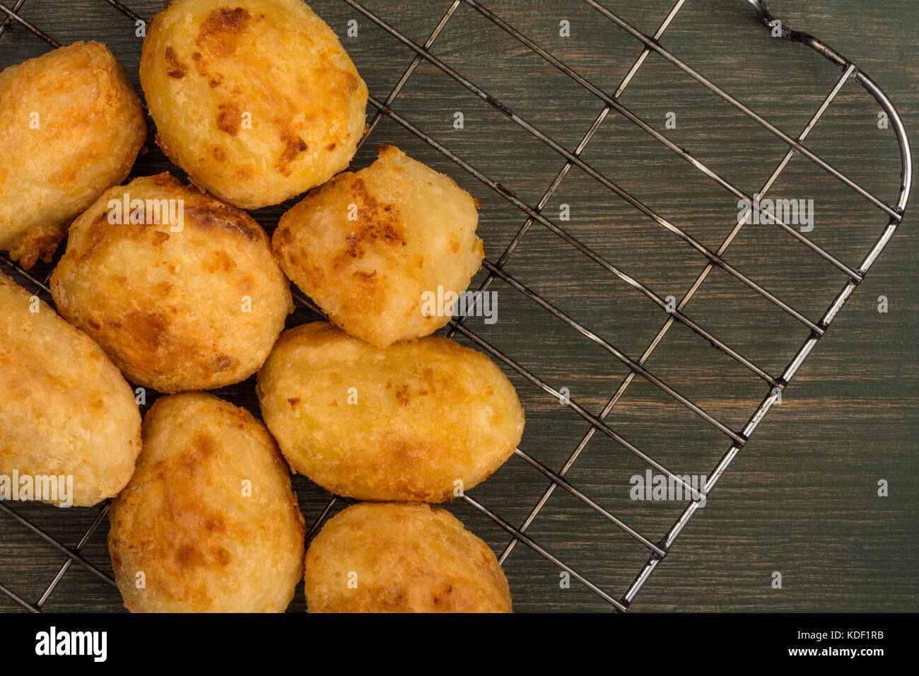 Roast Potatoes on a Steel Kitchen Cooling Rack On A Green Wooden ...