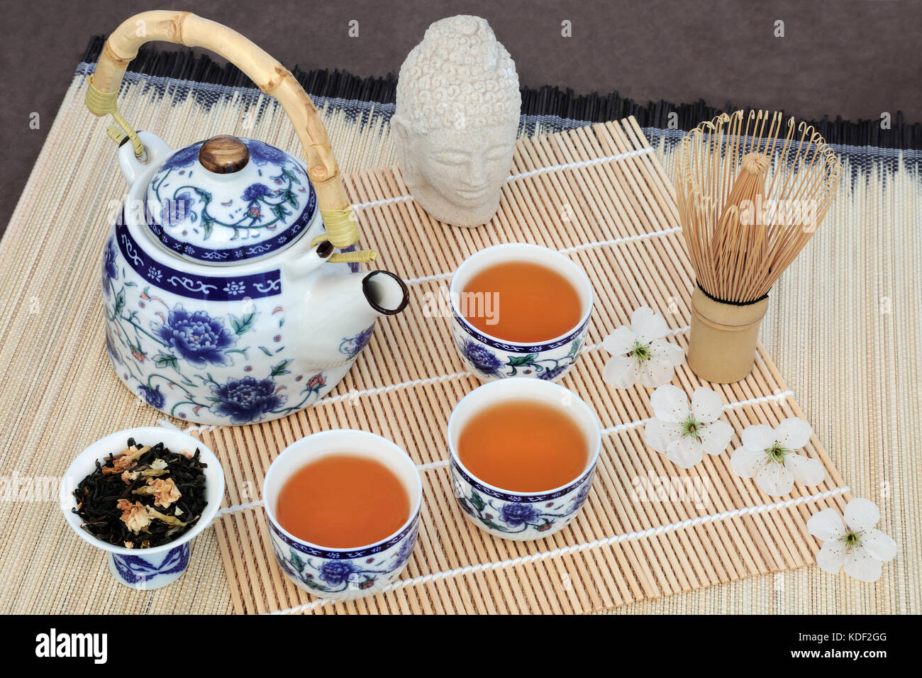 Jasmine tea with cherry blossom, stone buddha head, teapot, cups ...